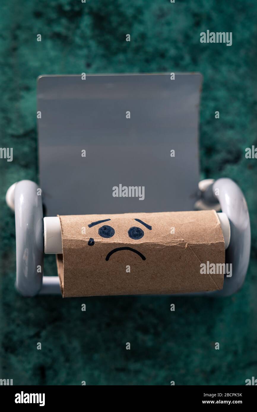 Toilet paper roll finished in the bathroom with a picture of a sad face ...