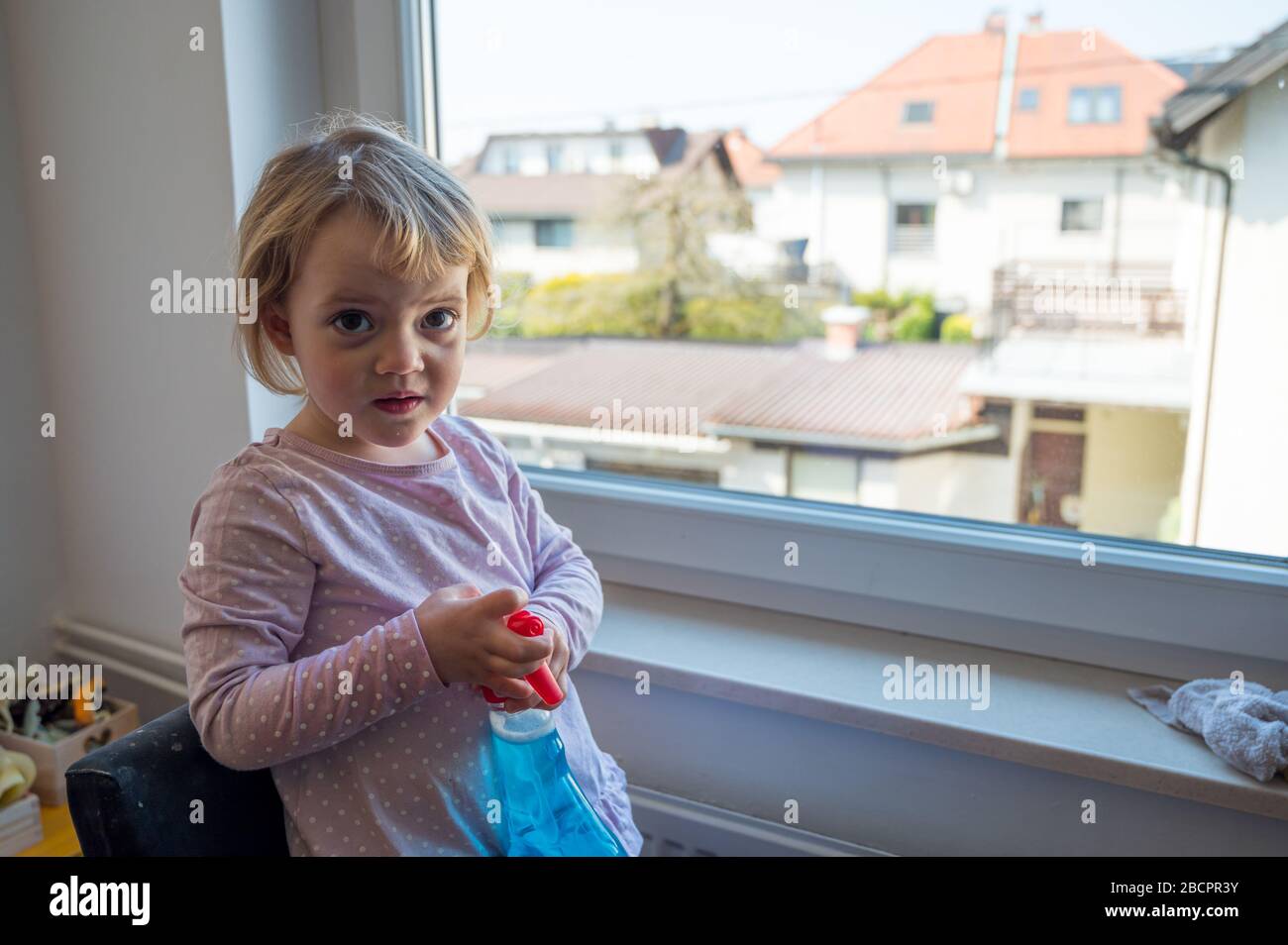 Cute girl cleaning windows in her room Stock Photo - Alamy