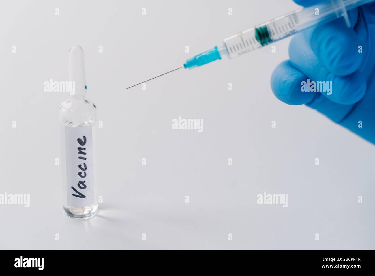 Medical vial and syringe in doctors hand against white background ...