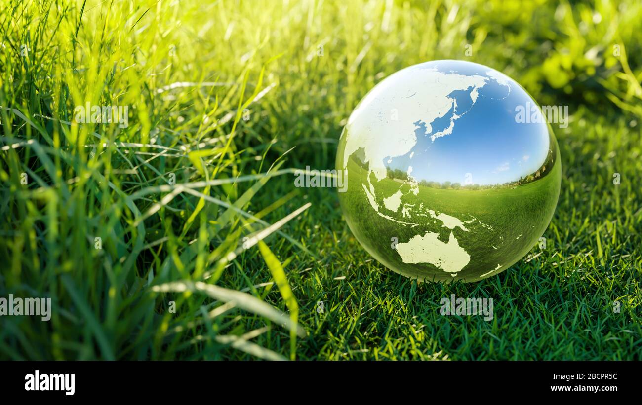 Planet Earth crystal ball on a green grass field Environmental ...
