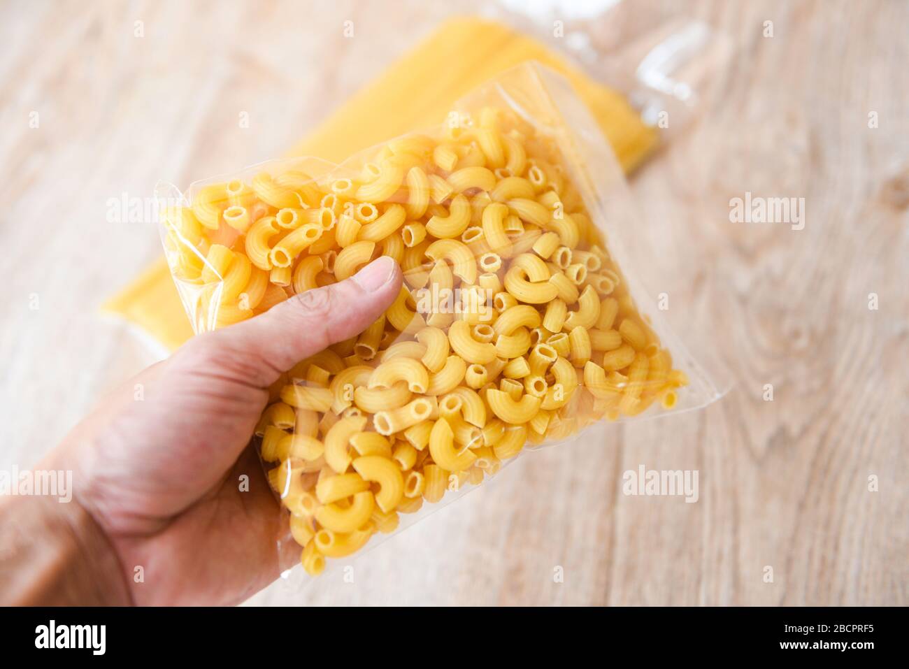 Macaroni in package in hand / raw macaroni vermicelli pasta product dry ...