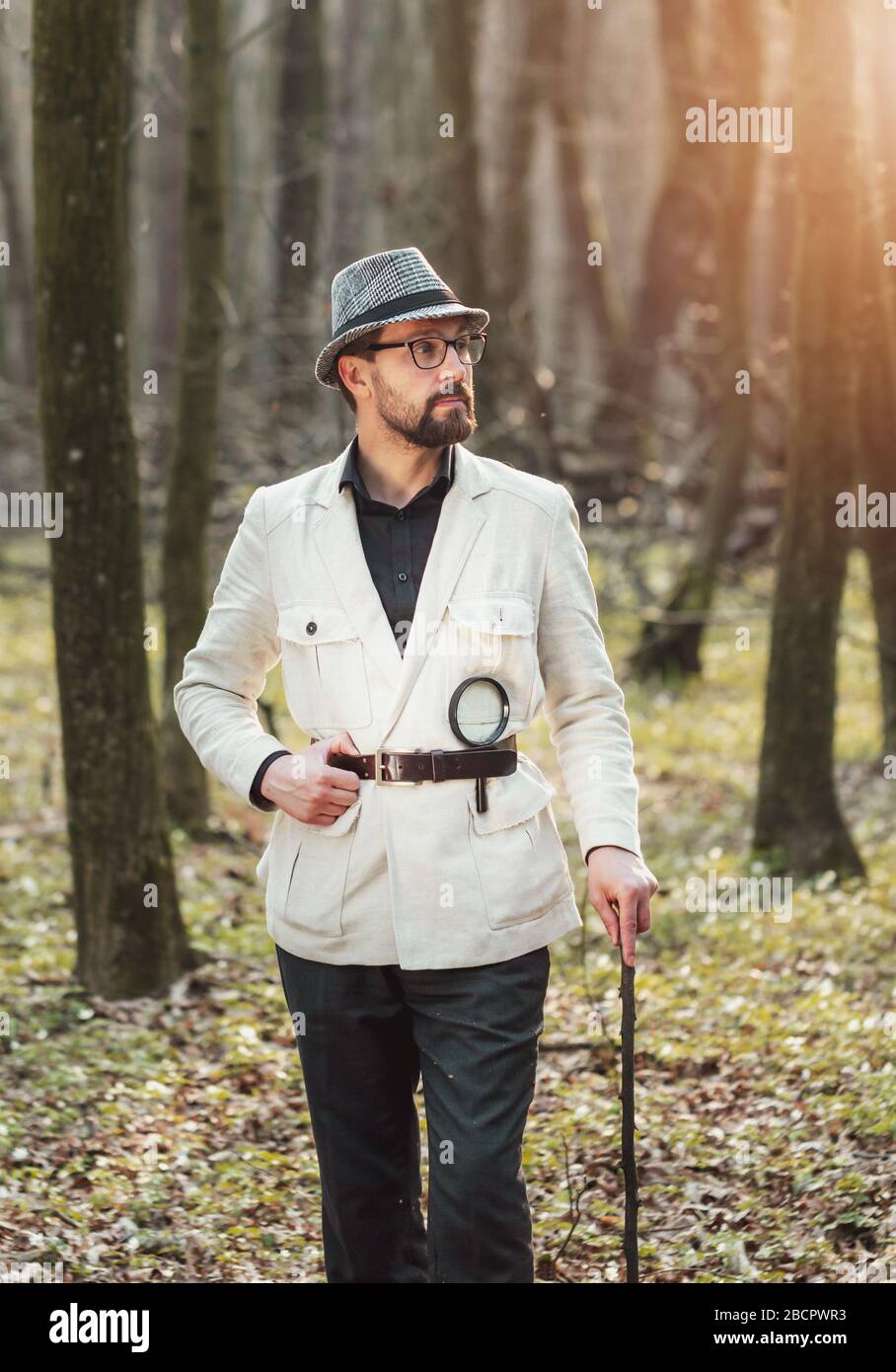 Pensive man standing among trees Stock Photo - Alamy