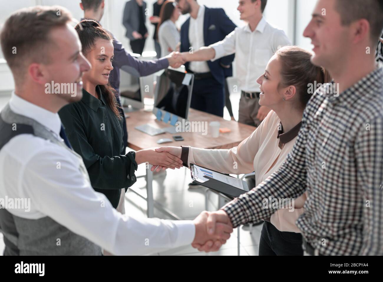 Manager congratulating a young employee with a handshake Stock Photo ...