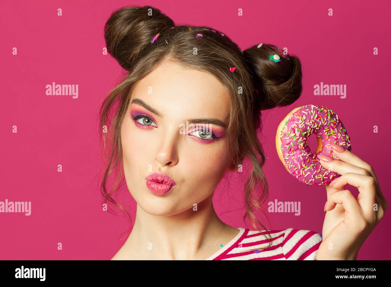 Colorful fashion portrait of nice model woman with donuts on vivid pink ...