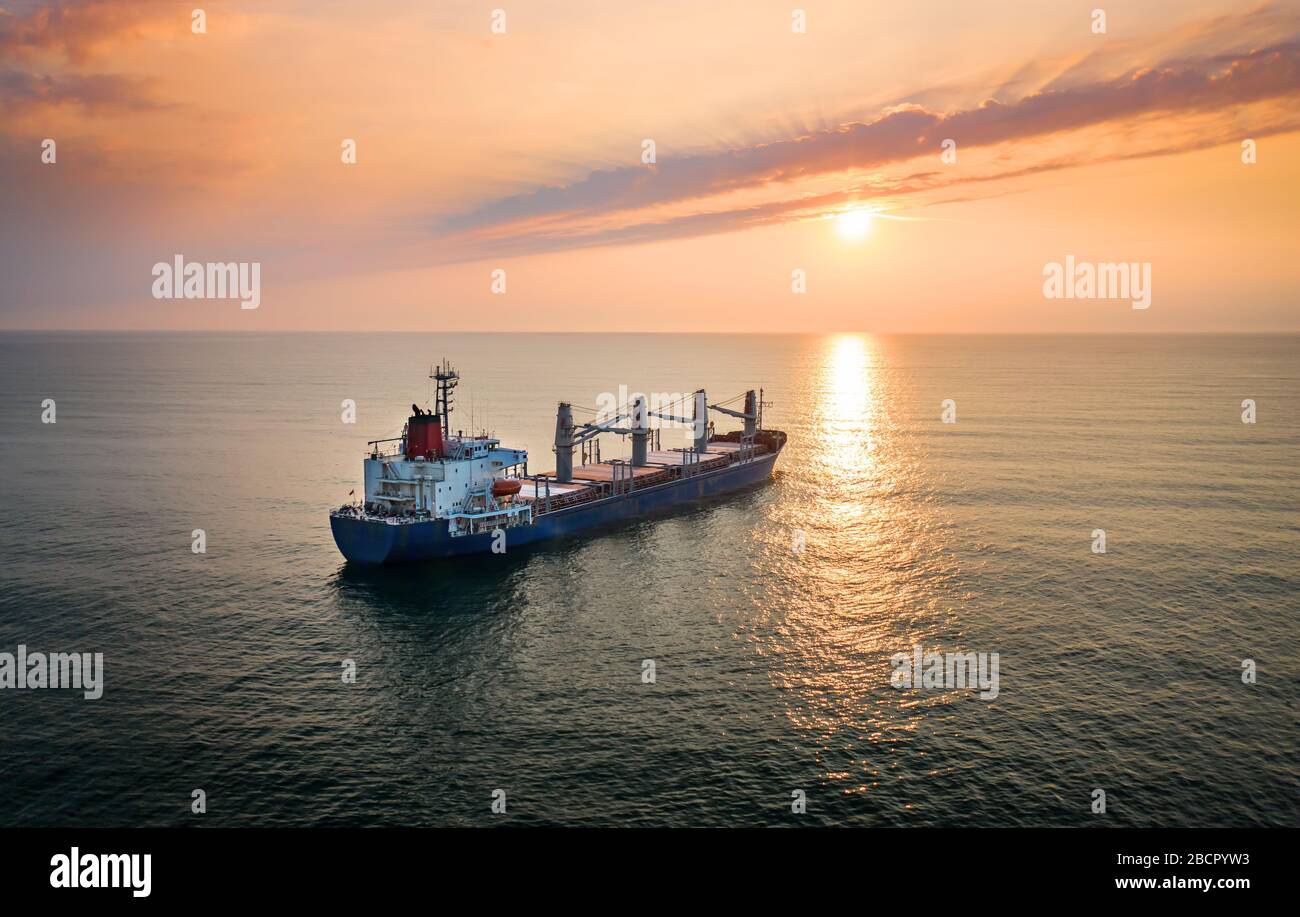 Cargo ship in the ocean on the sunrise Stock Photo - Alamy