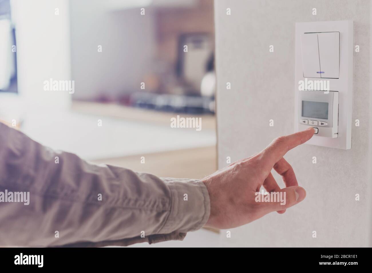 Men hand setting the temperature on control panel of DHW or central ...