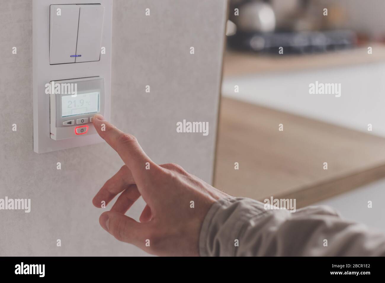 Men hand setting the temperature on control panel of DHW or central ...