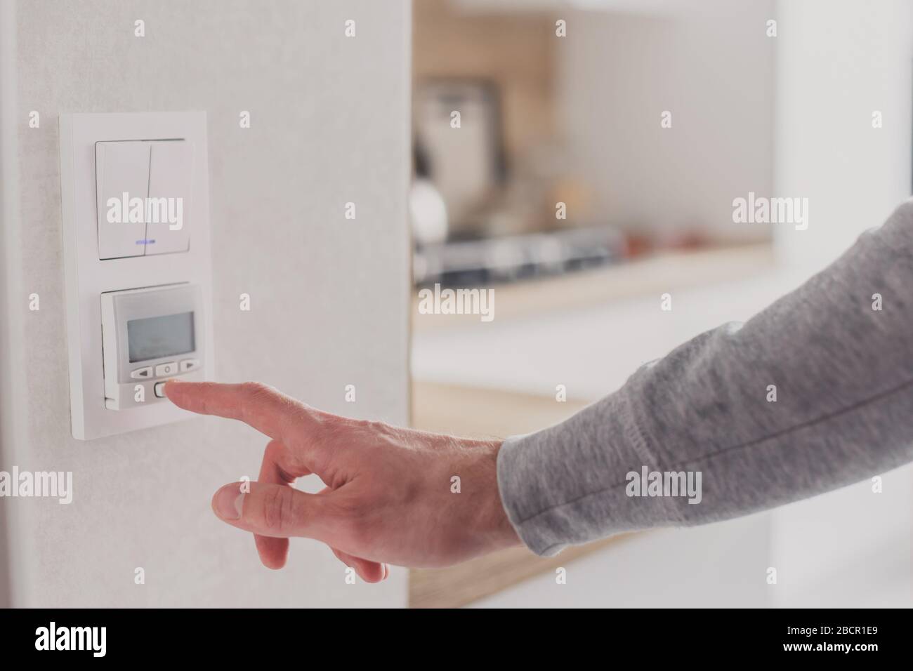 Men hand setting the temperature on control panel of DHW or central ...