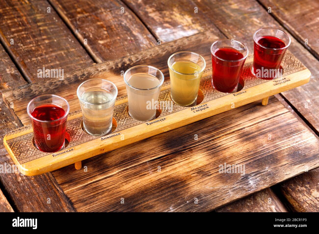 Colourful set of alcoholic cocktails in shot glasses shooters on wooden ...