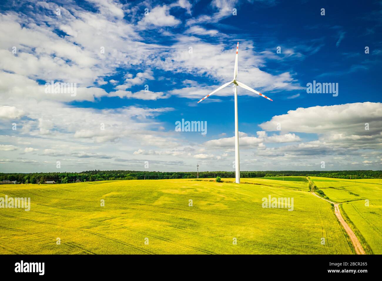 Flying above big wind turbine on rape field Stock Photo - Alamy