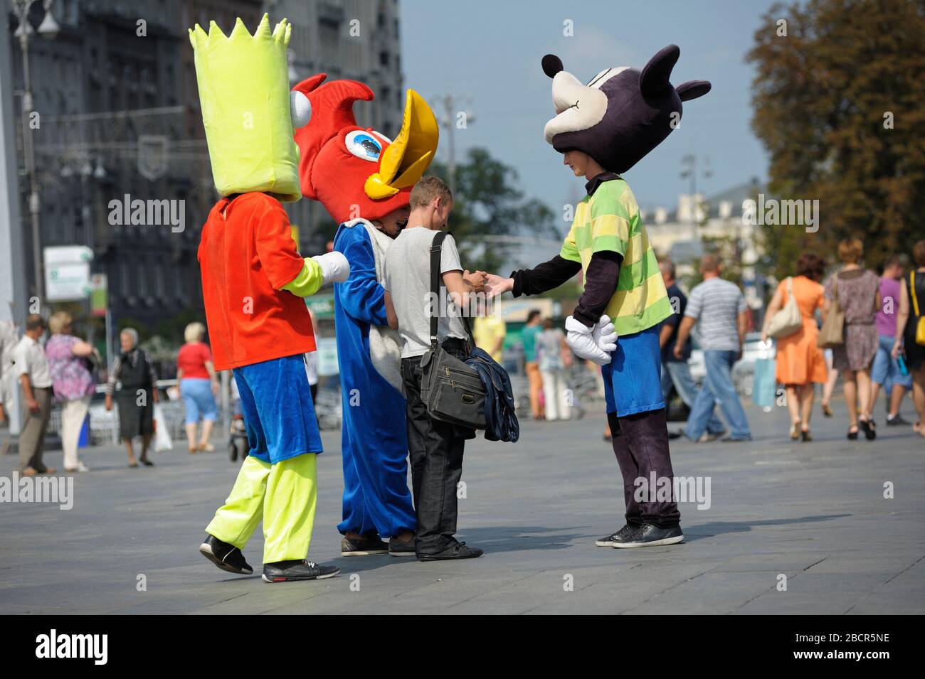 Advertising promoters in animal costumes stand on a street trying to ...