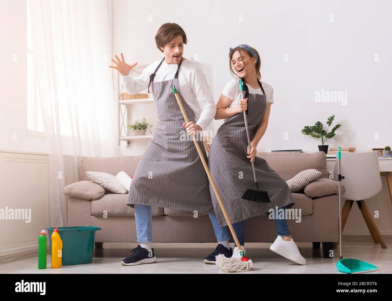 Couple Having Fun While Tidying Home, Dancing With Mop And Broom Stock ...