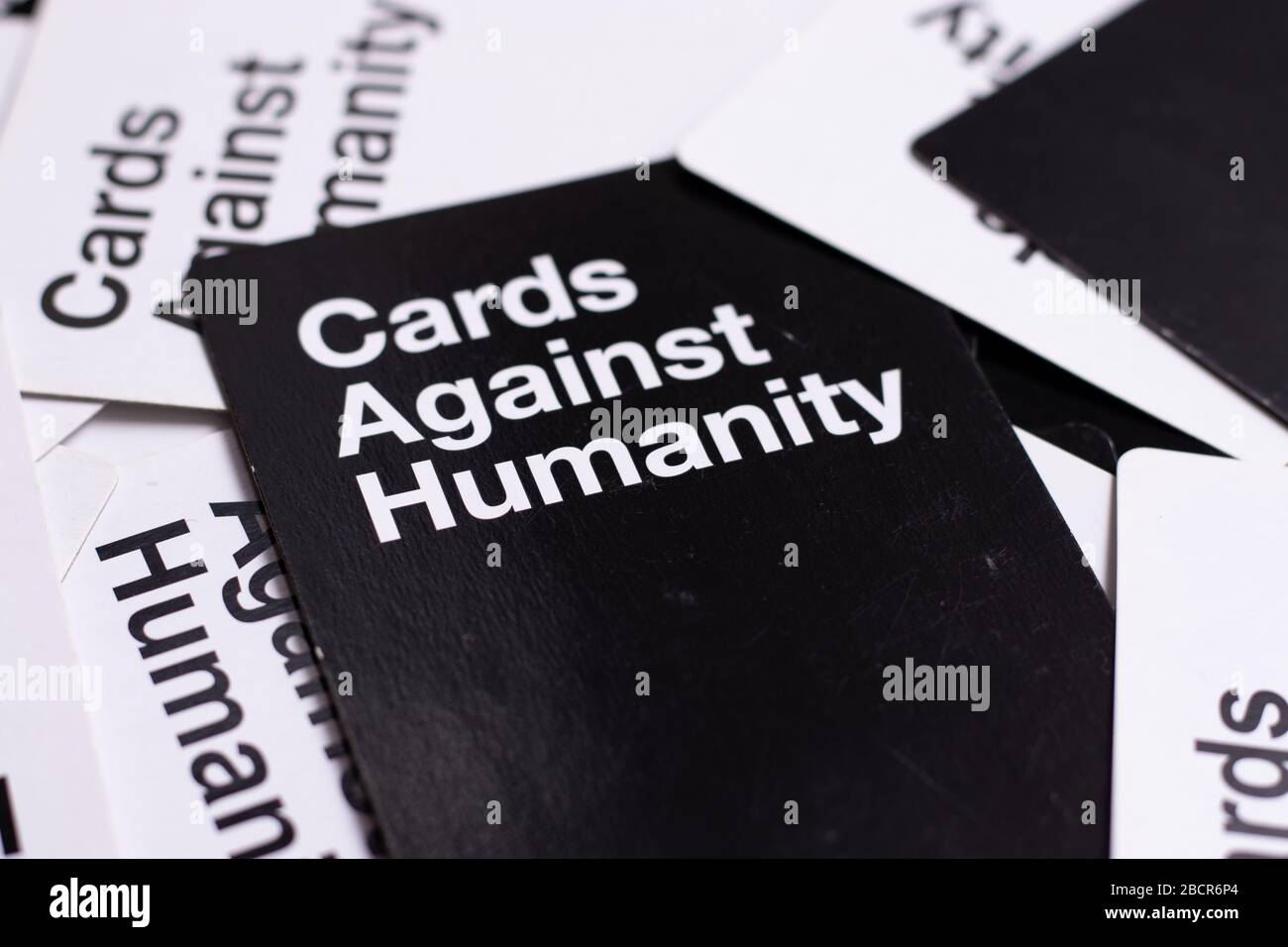 Black cards against humanity card viewed at an angle, flat lay of many ...