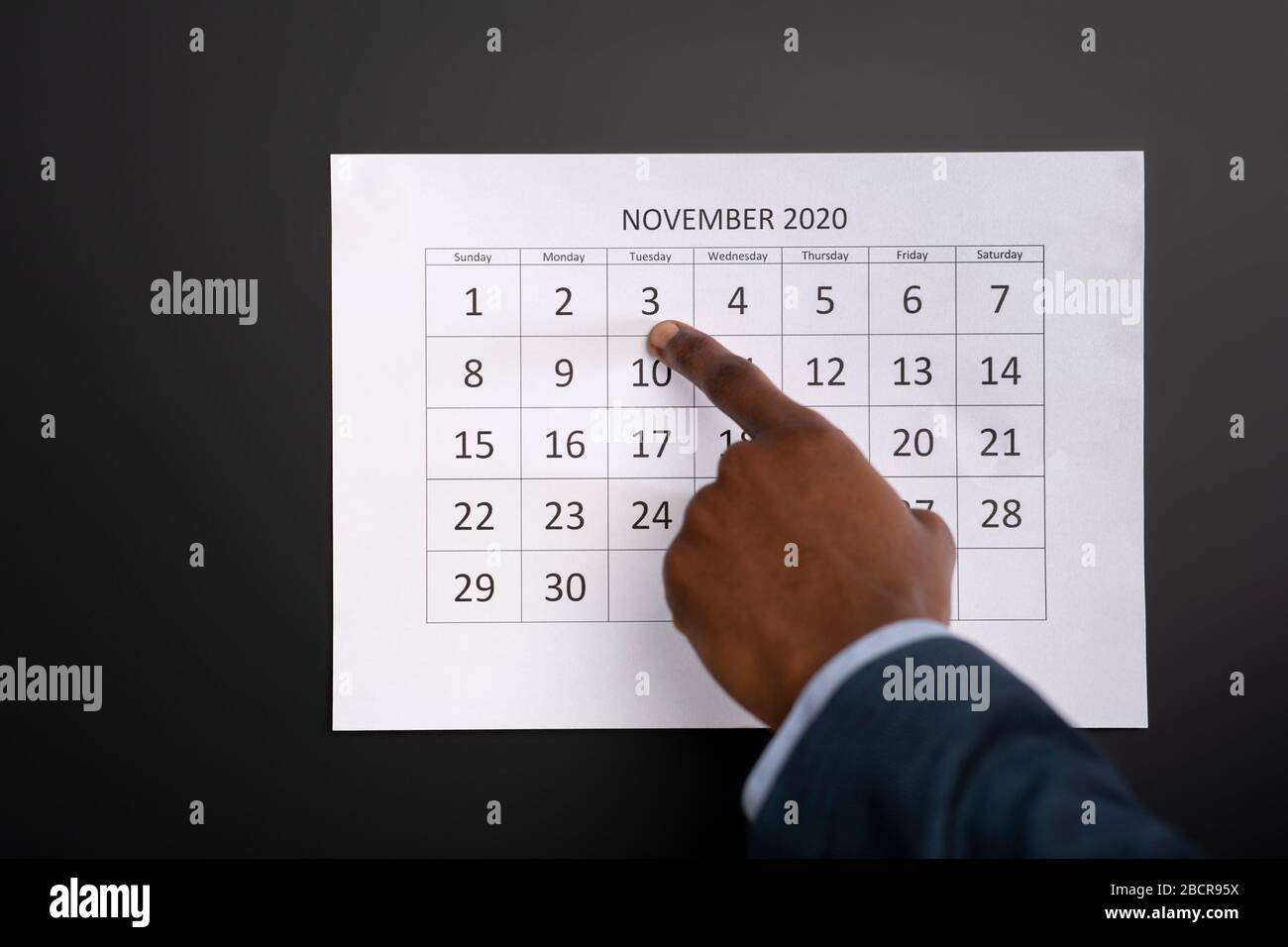 African man showing with finger on calendar date Stock Photo - Alamy