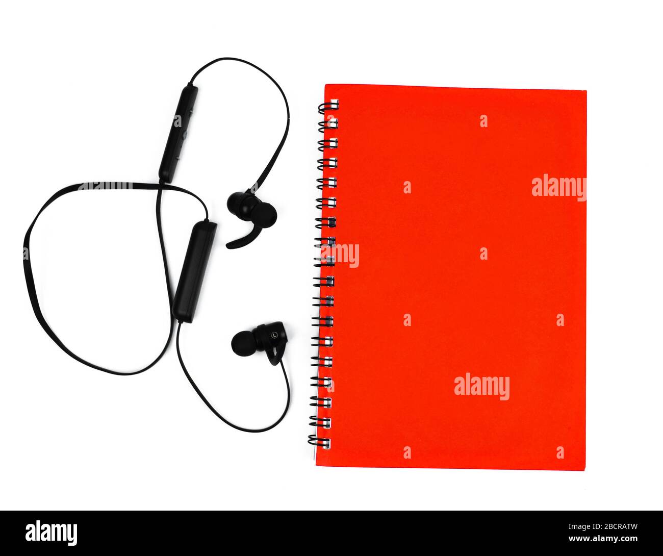 One black colored ear phone placed beside a single red colored note ...