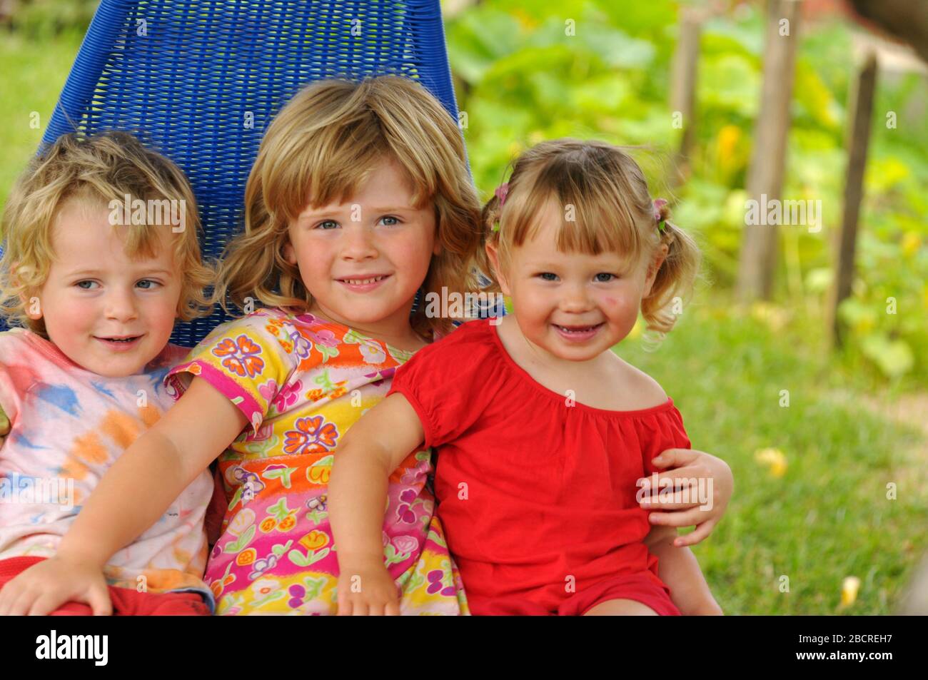 The three little smiling girls in park Stock Photo - Alamy