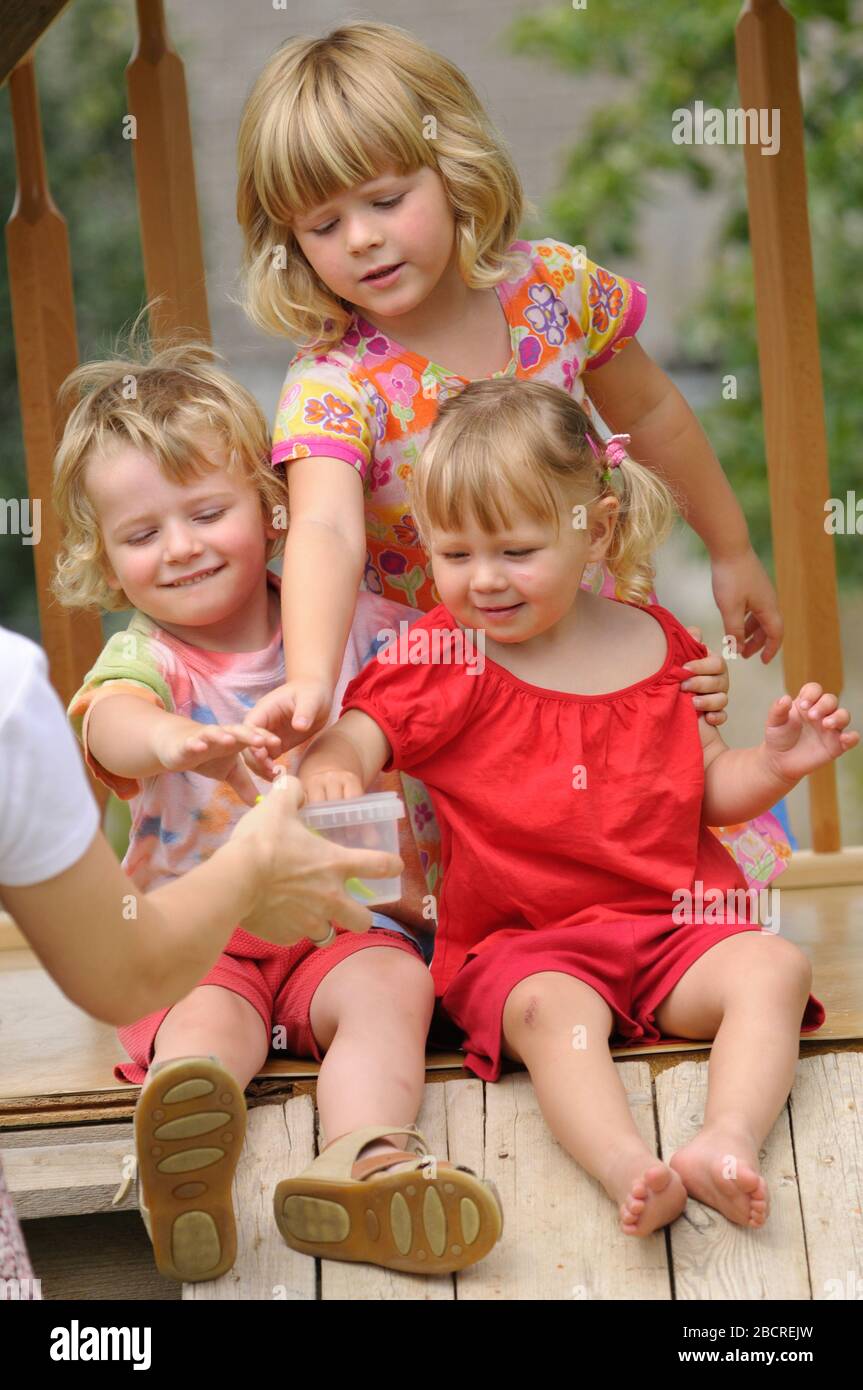 The three little smiling girls in park Stock Photo - Alamy