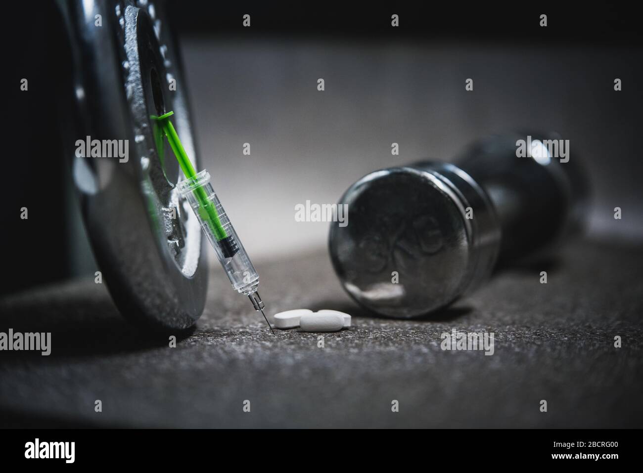 sport stimulants. metal barbells with syringe Stock Photo - Alamy