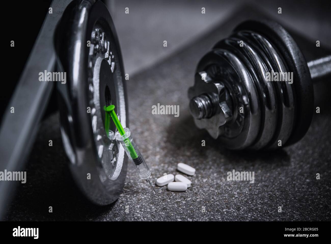 sport stimulants. metal barbells with syringe Stock Photo - Alamy