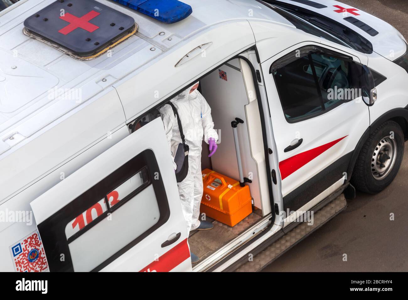 A doctor at an emergency ambulance service car goes to a patient with a ...