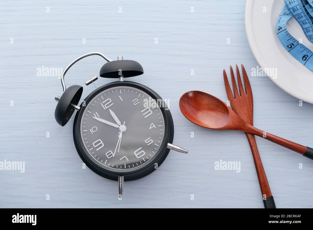 clock, wooden spoon and fork with measuring tape Stock Photo - Alamy