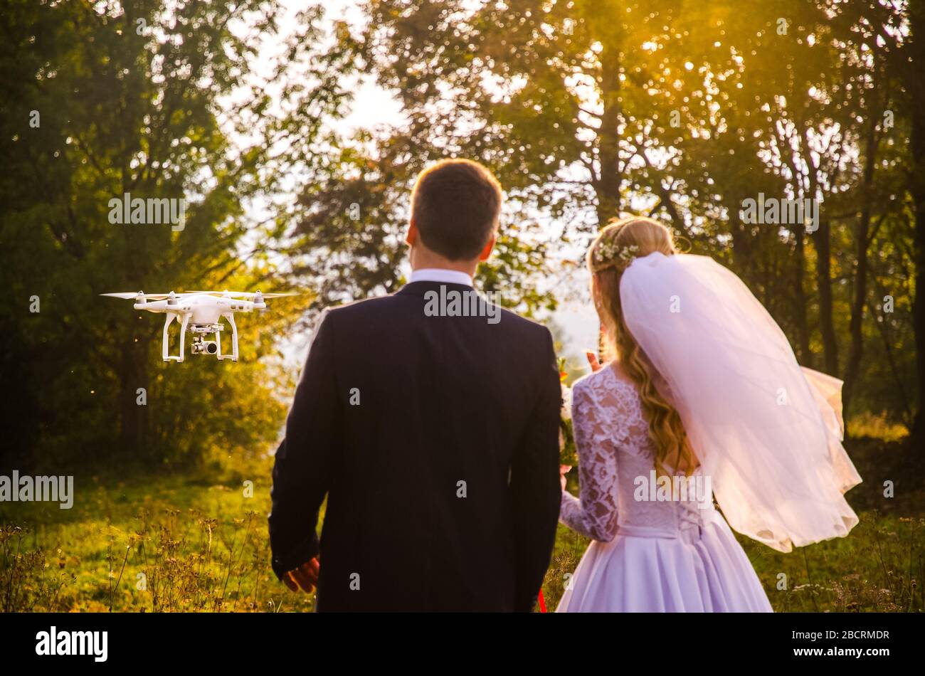 Wedding couple pose for drone photo in autumn nature Stock Photo - Alamy