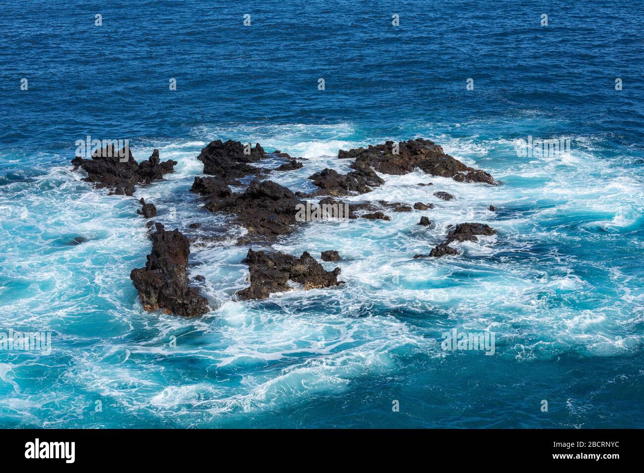 Volcanic rock formation, cliffs of black lava on the rocky shore with ...