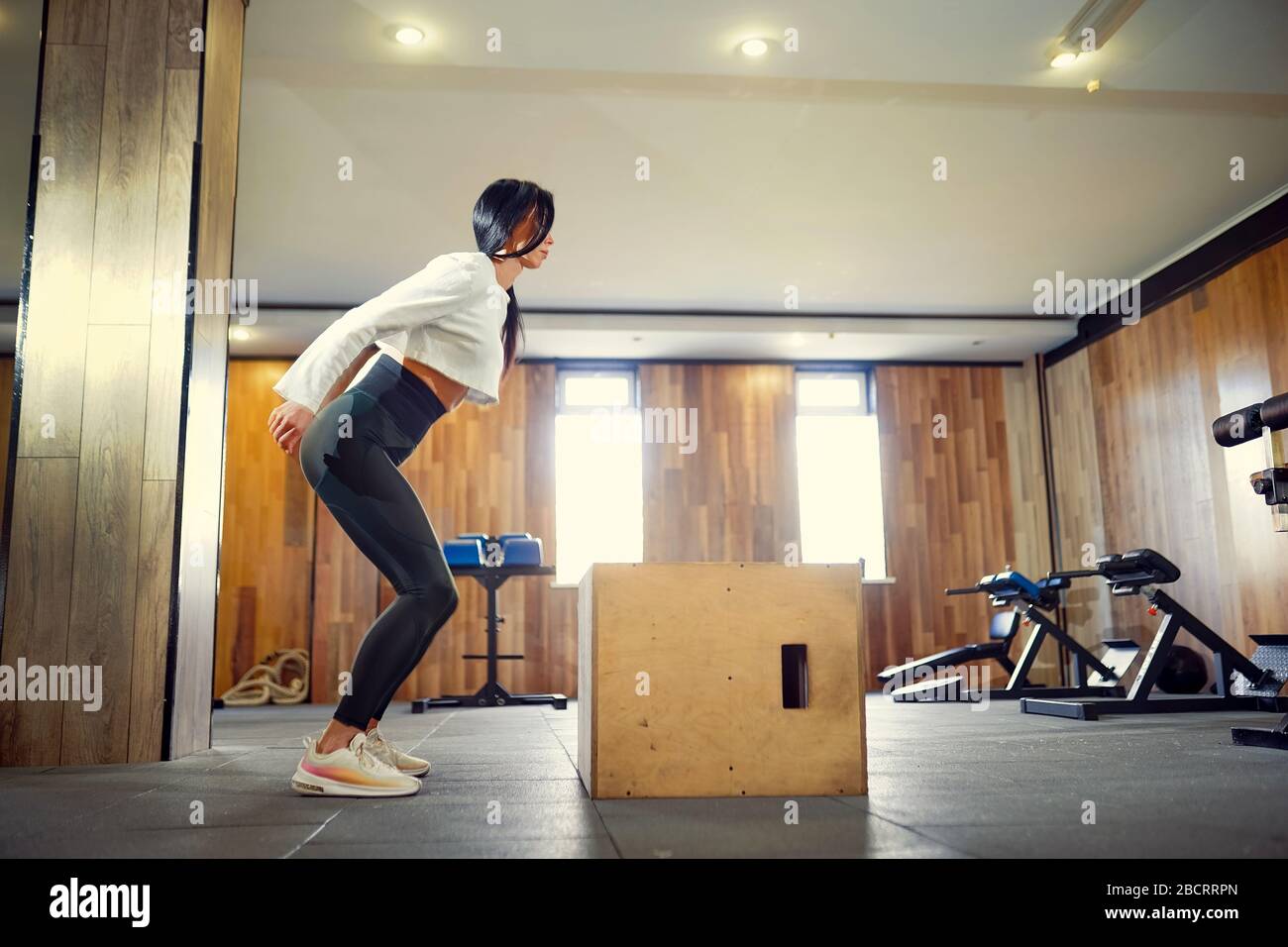 Shot of young woman working out with a box at the gym. Female athlete ...
