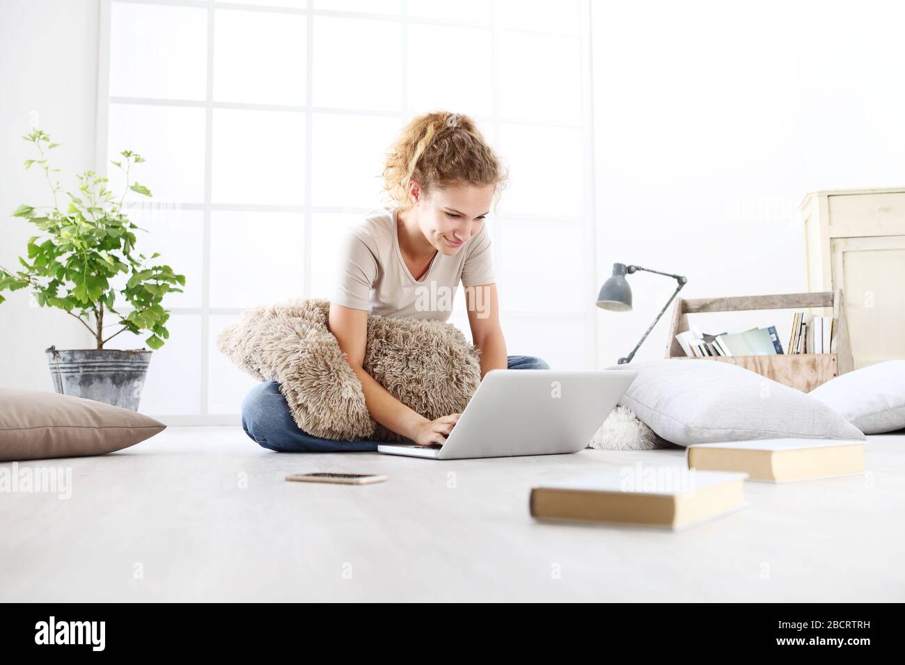young woman sitting in living room at the computer, stay at home ...