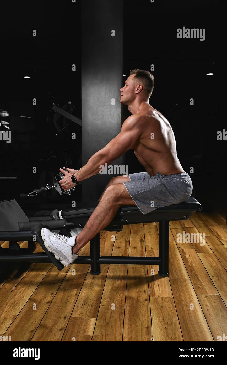 Side view of a strong young man with athletic body doing exercises on ...
