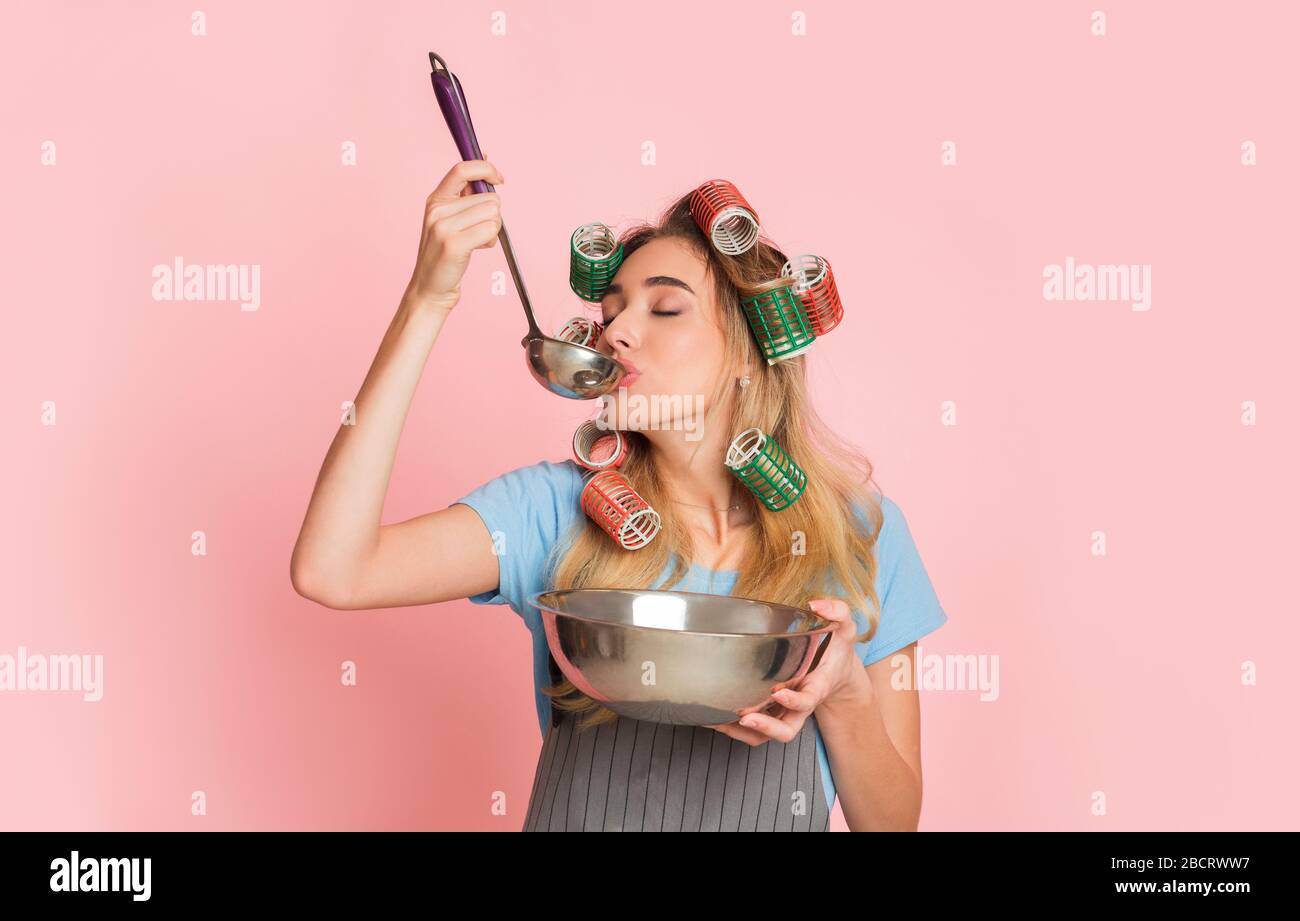 Cooking delicious dinner. Funny housewife tasting food Stock Photo - Alamy