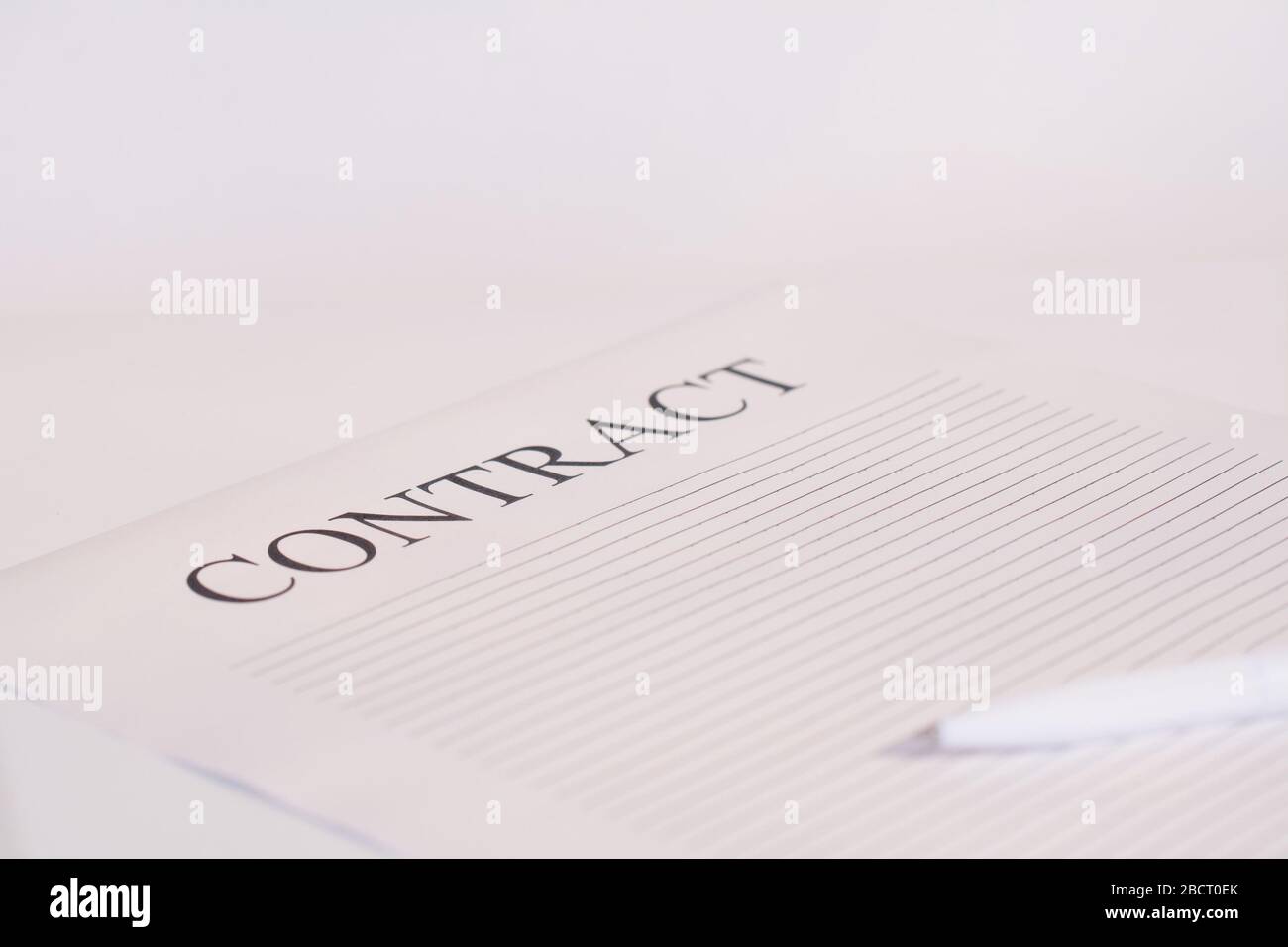 Contract paper and pen on white desk background. Focus on title ...