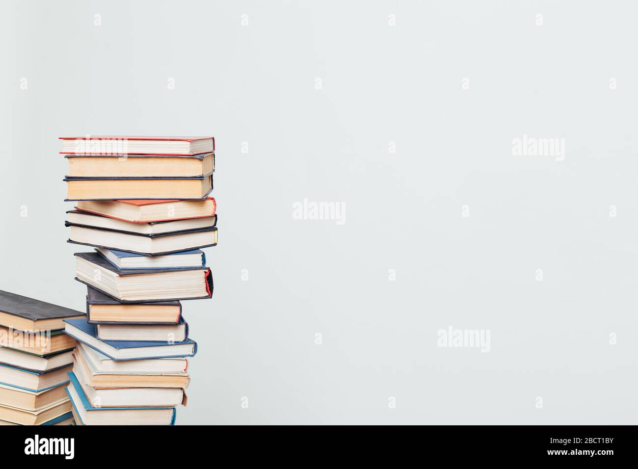 many stacks of educational books at home preparing for exams on a white ...