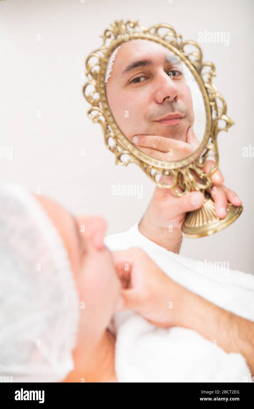 Young man holds mirror, which reflects his face Stock Photo - Alamy