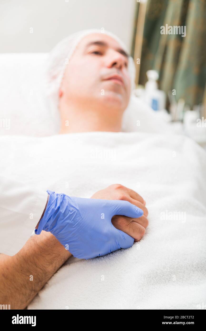 Close up of doctor's hand squeezing patient's hand Stock Photo - Alamy