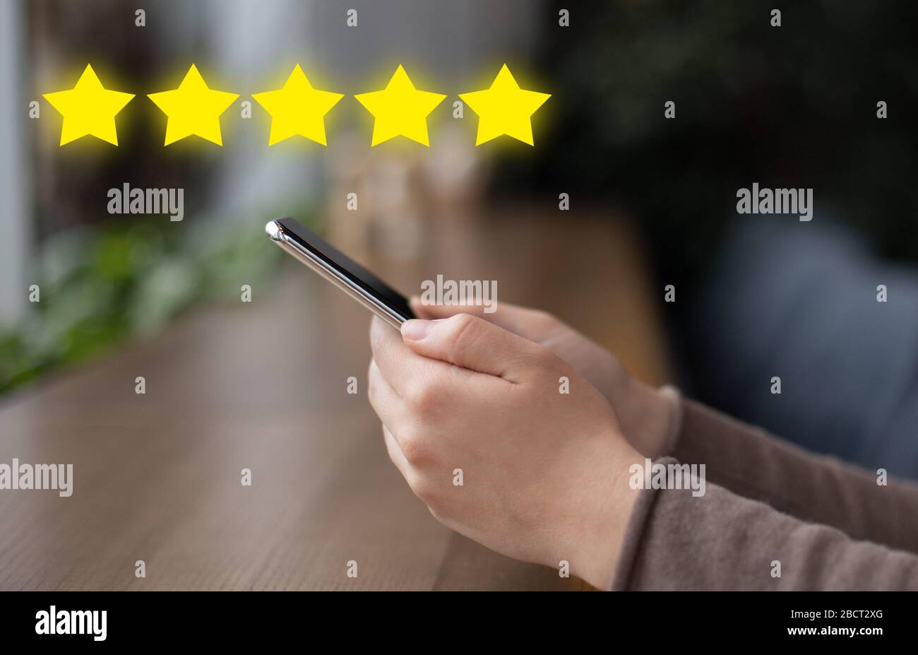 Girl hand holding cell phone with icon five star symbol Stock Photo - Alamy