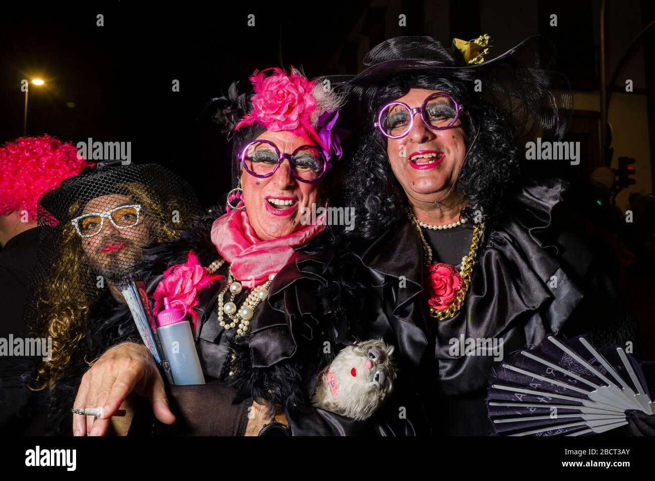 A group of young men, dressed up as women in mourning clothes and ...