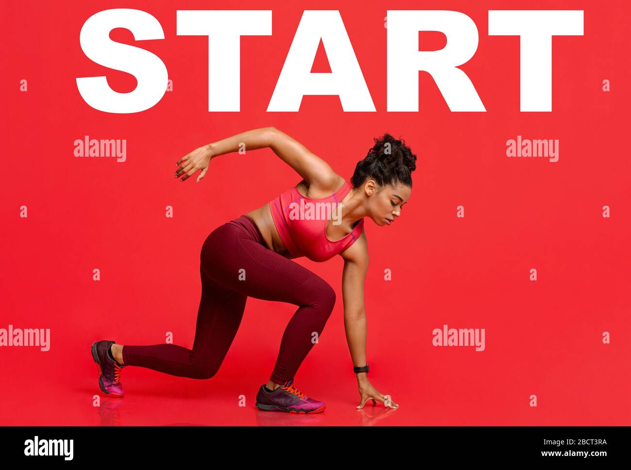 Motivated athlete girl in ready pose before running with lettering ...