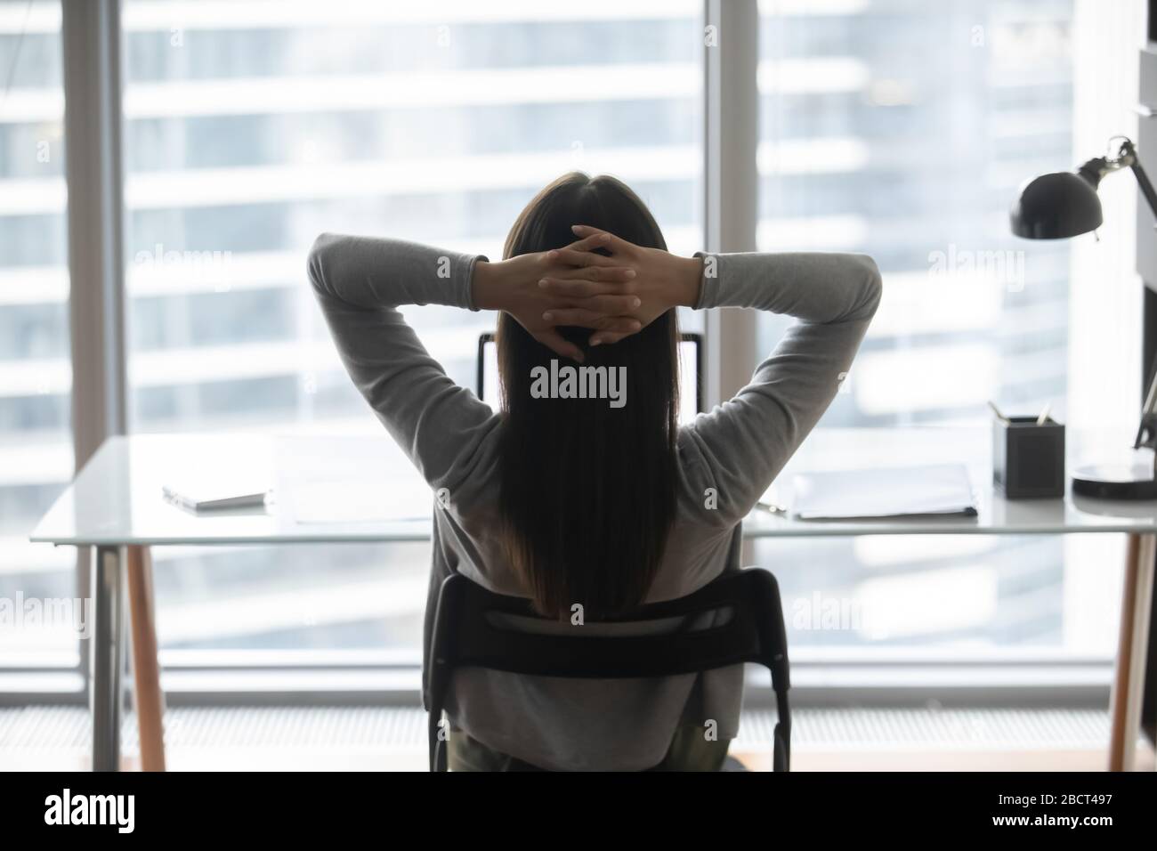 Back view of young woman employee relax at workplace Stock Photo - Alamy