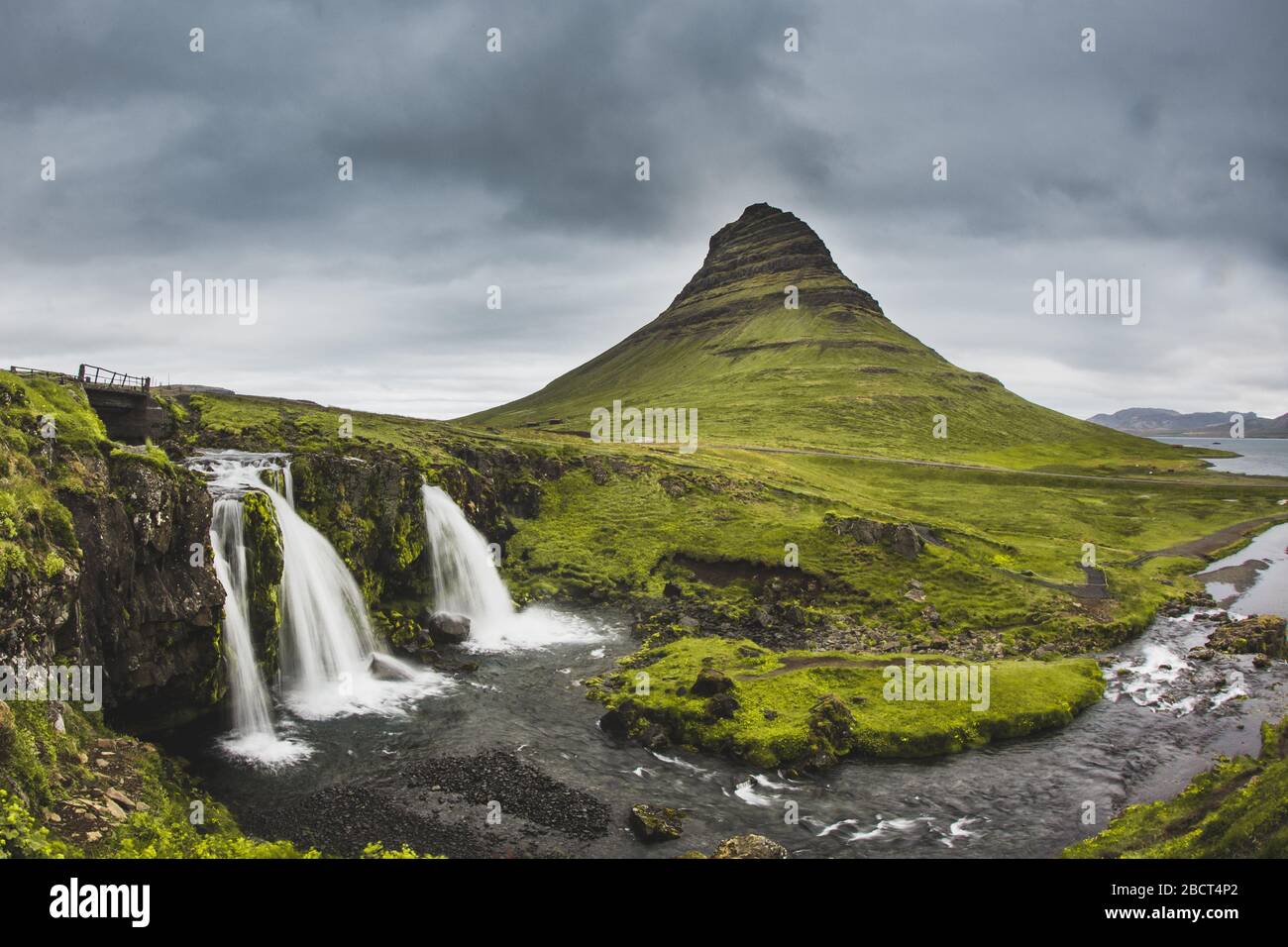 Kirkjufellsfoss waterfall and Kirkjufell mountain behind. On very ...
