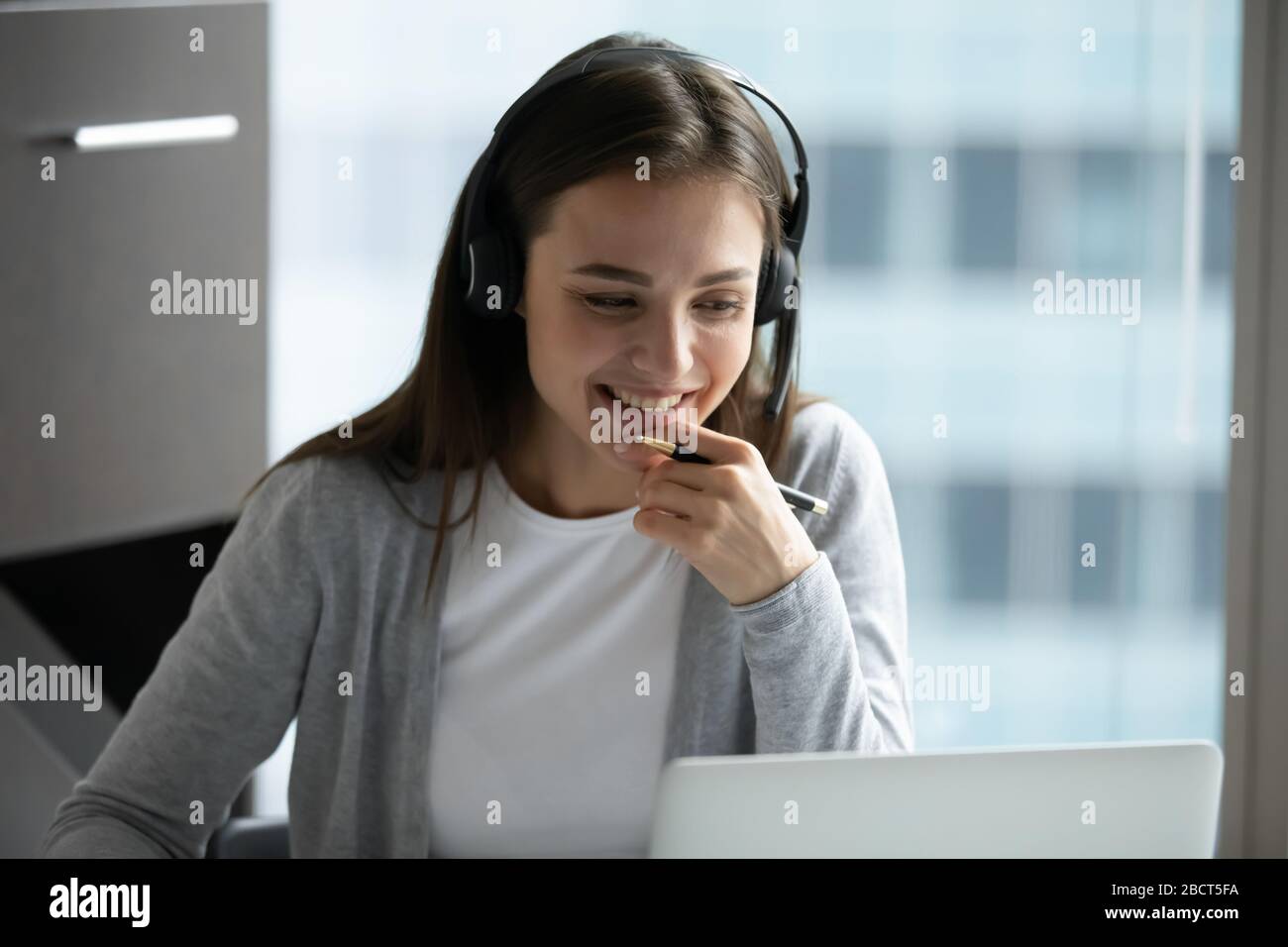 Smiling female employee in headphones have video call Stock Photo - Alamy