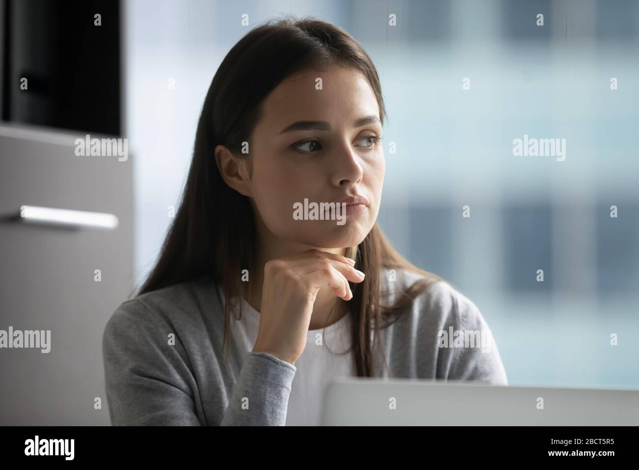Pensive female employee look in distance thinking Stock Photo - Alamy