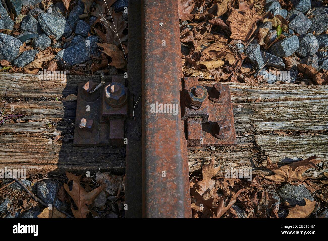 Detail of an old and rusty railroad track with a weathered railroad tie ...