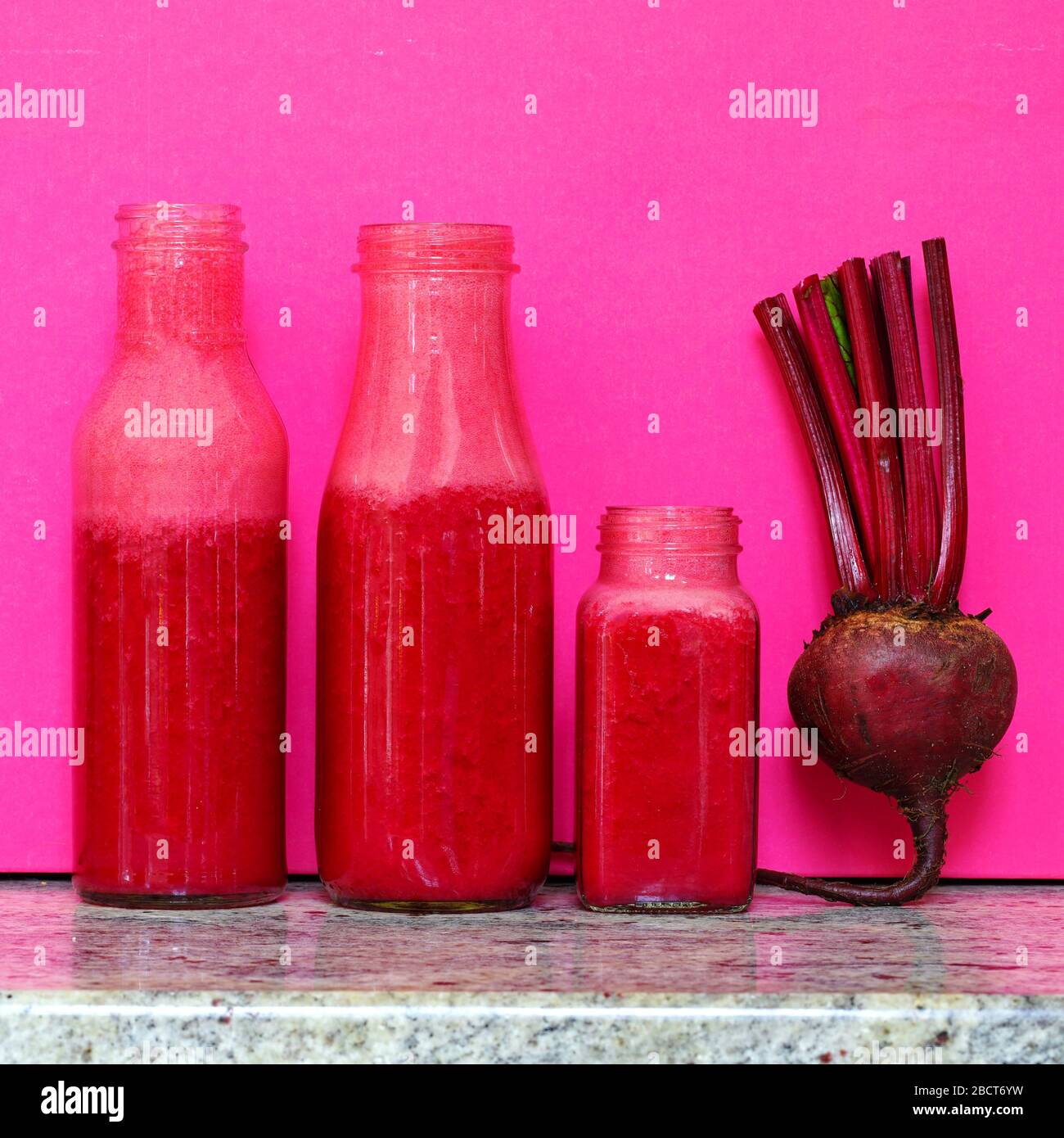 Glass bottles filled with colorful fresh homemade beet smoothies on a ...