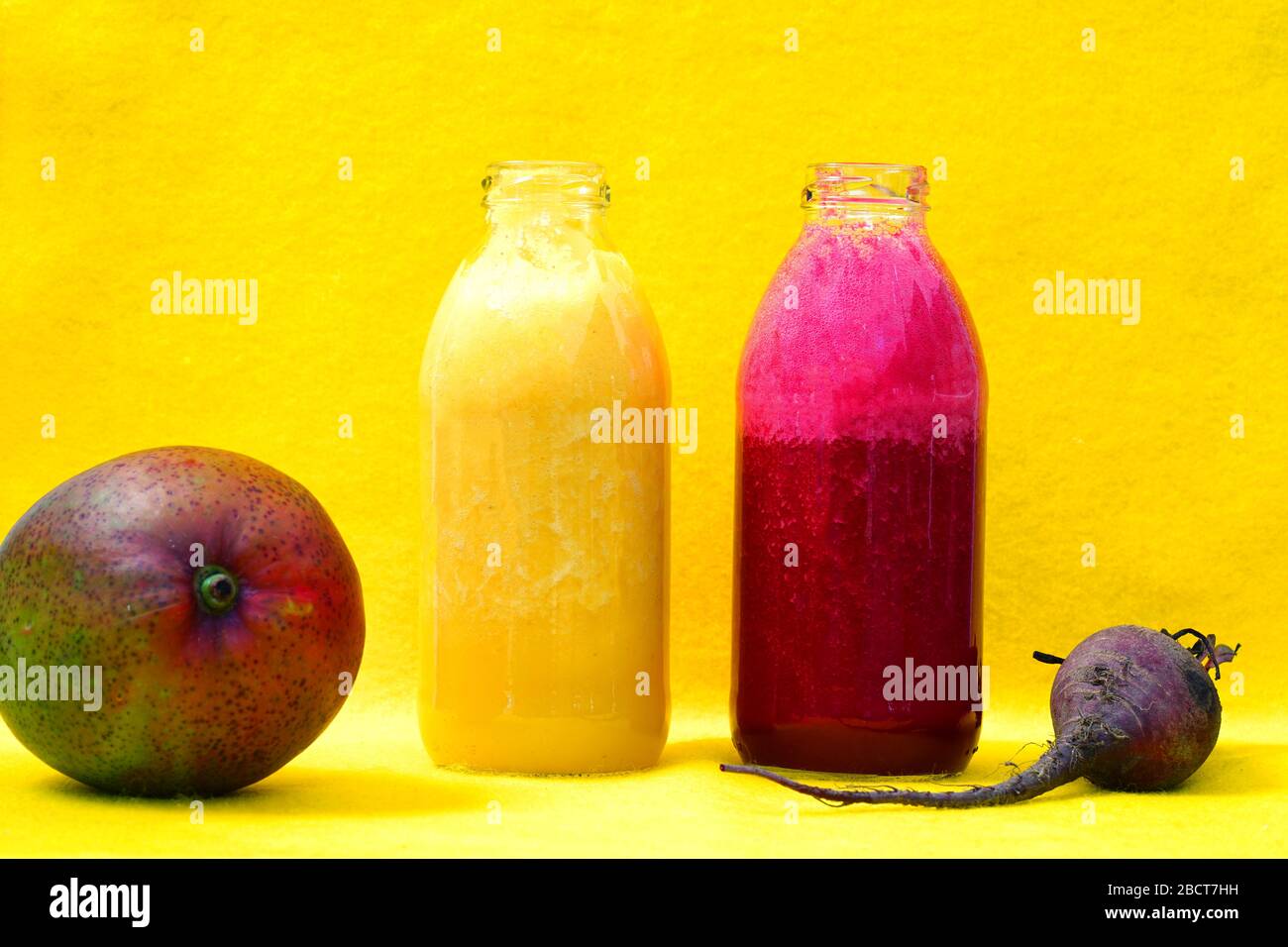 Glass bottles filled with colorful fresh homemade beet smoothies on a ...