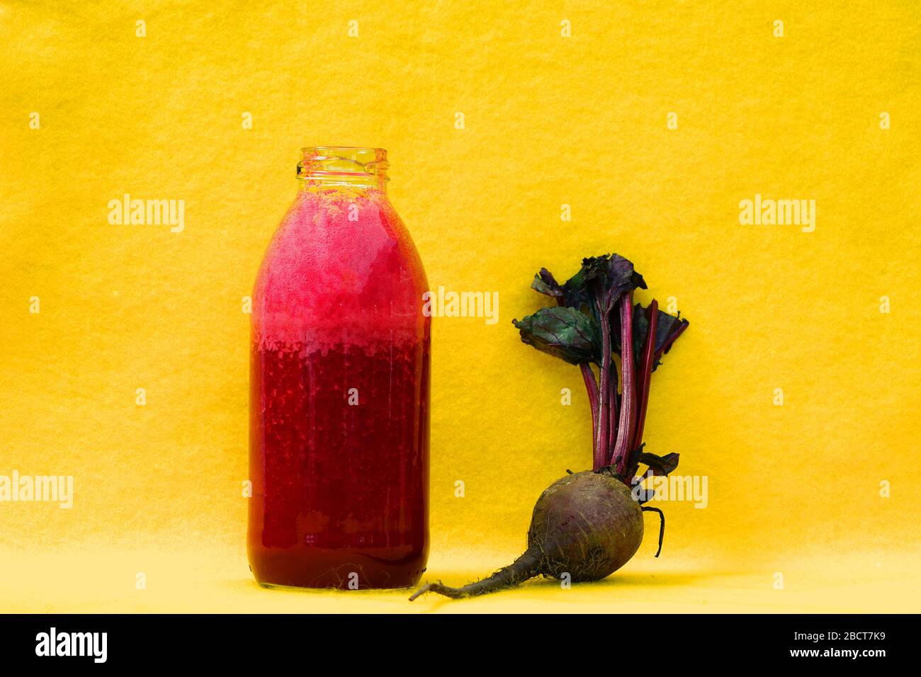 Glass bottles filled with colorful fresh homemade beet smoothies on a ...