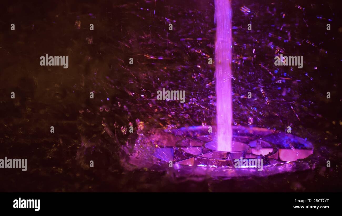 Splashes of colorful fountain. Water illuminated in diverse colors ...