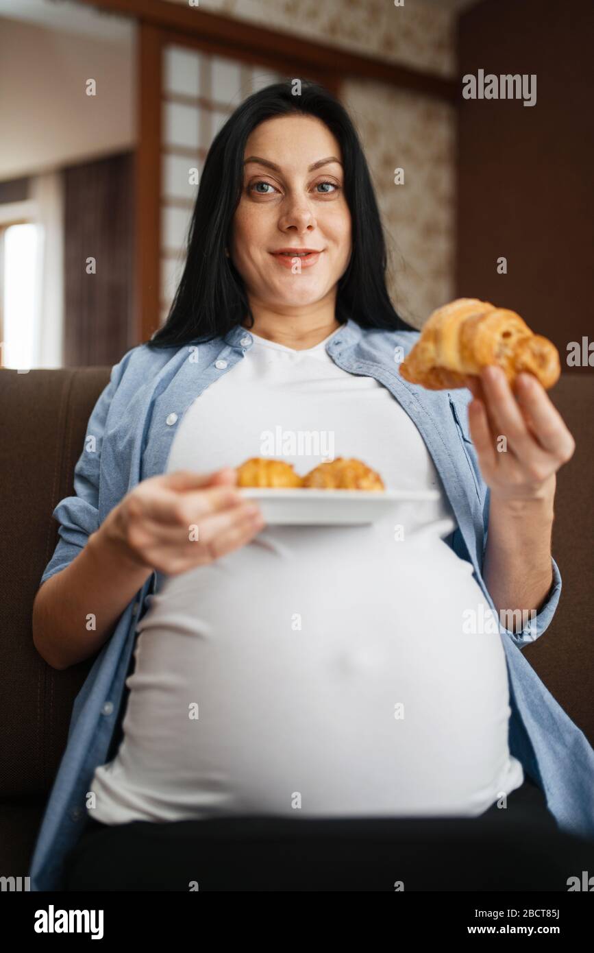 Pregnant woman with belly eating sweets Stock Photo - Alamy