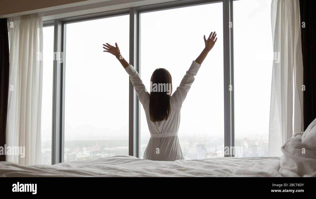 Happy young woman wake up stretching in morning Stock Photo - Alamy