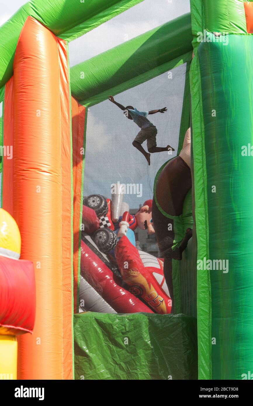A boy jumps into a plastic pit from a two-story height on a giant ...